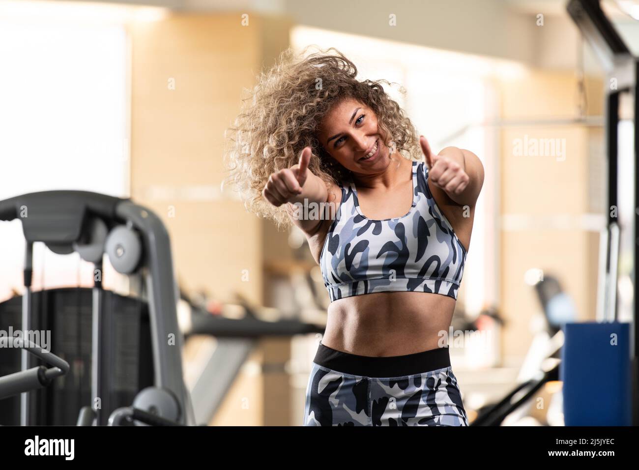 Healthy Young Woman Showing Thumbs Up While Standing Strong In The Gym ...