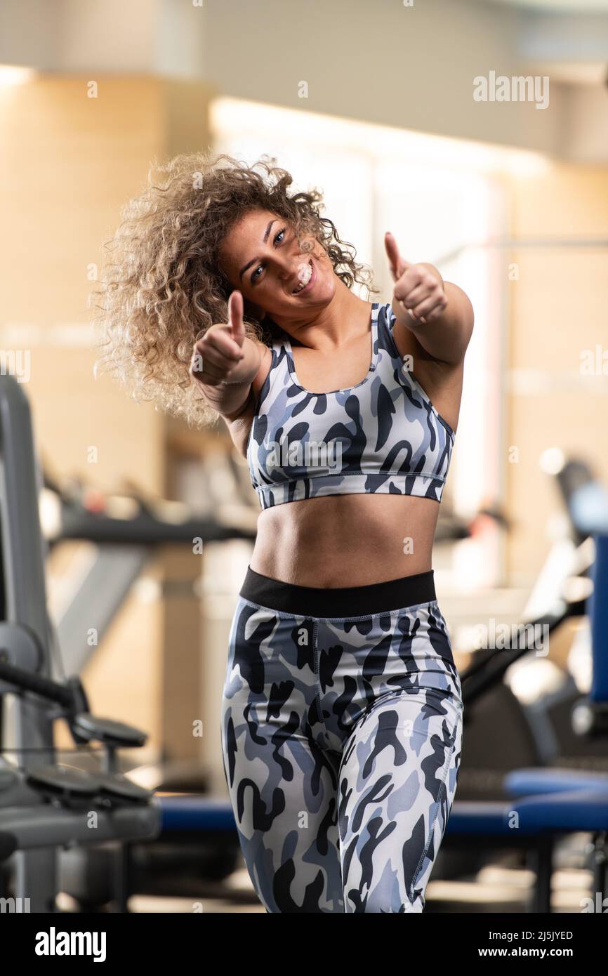 Healthy Young Woman Showing Thumbs Up While Standing Strong In The Gym ...