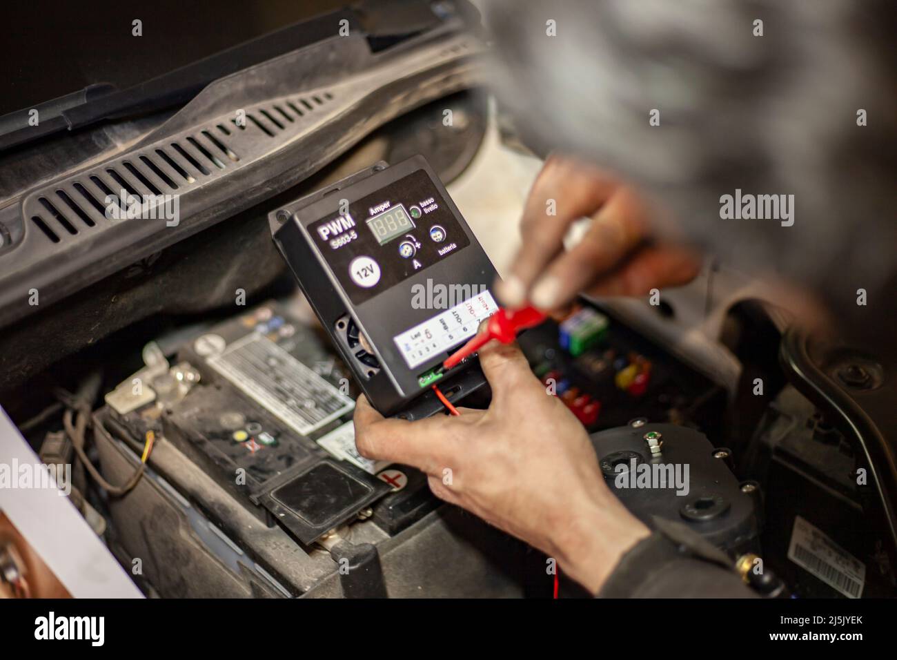 MILAN, ITALY 24 APRIL 2022: Mechanic's hands adjust the hydrogen system ...