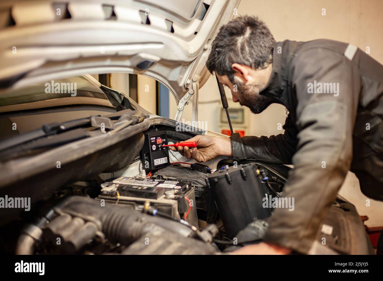 MILAN, ITALY 24 APRIL 2022: Mechanic's hands adjust the hydrogen system ...