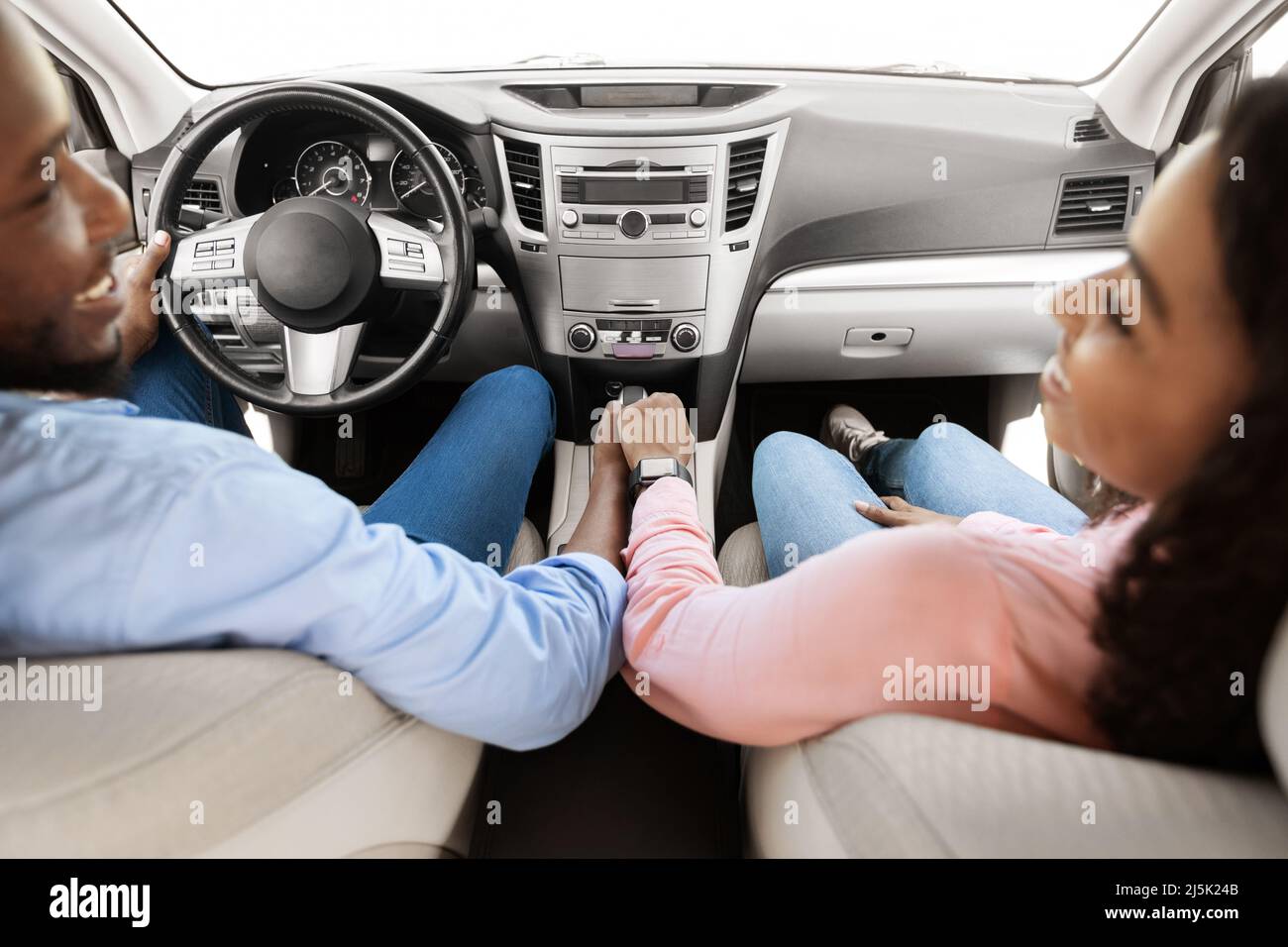 Black couple enjoying drive on car, holding hands Stock Photo - Alamy