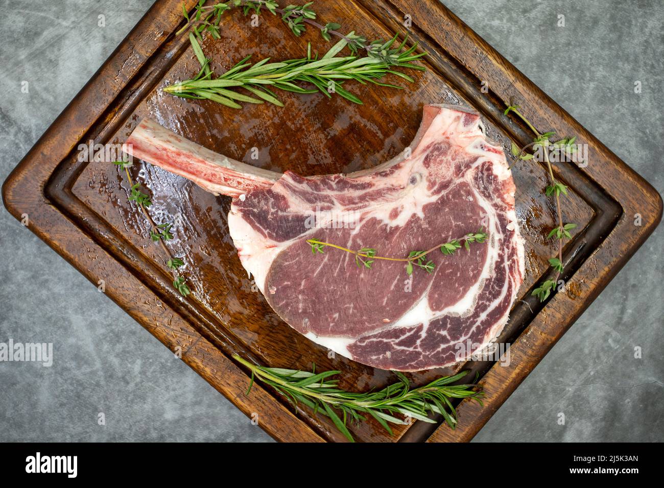 Raw Veal chop on dark background. Raw veal chop on wooden serving board ...