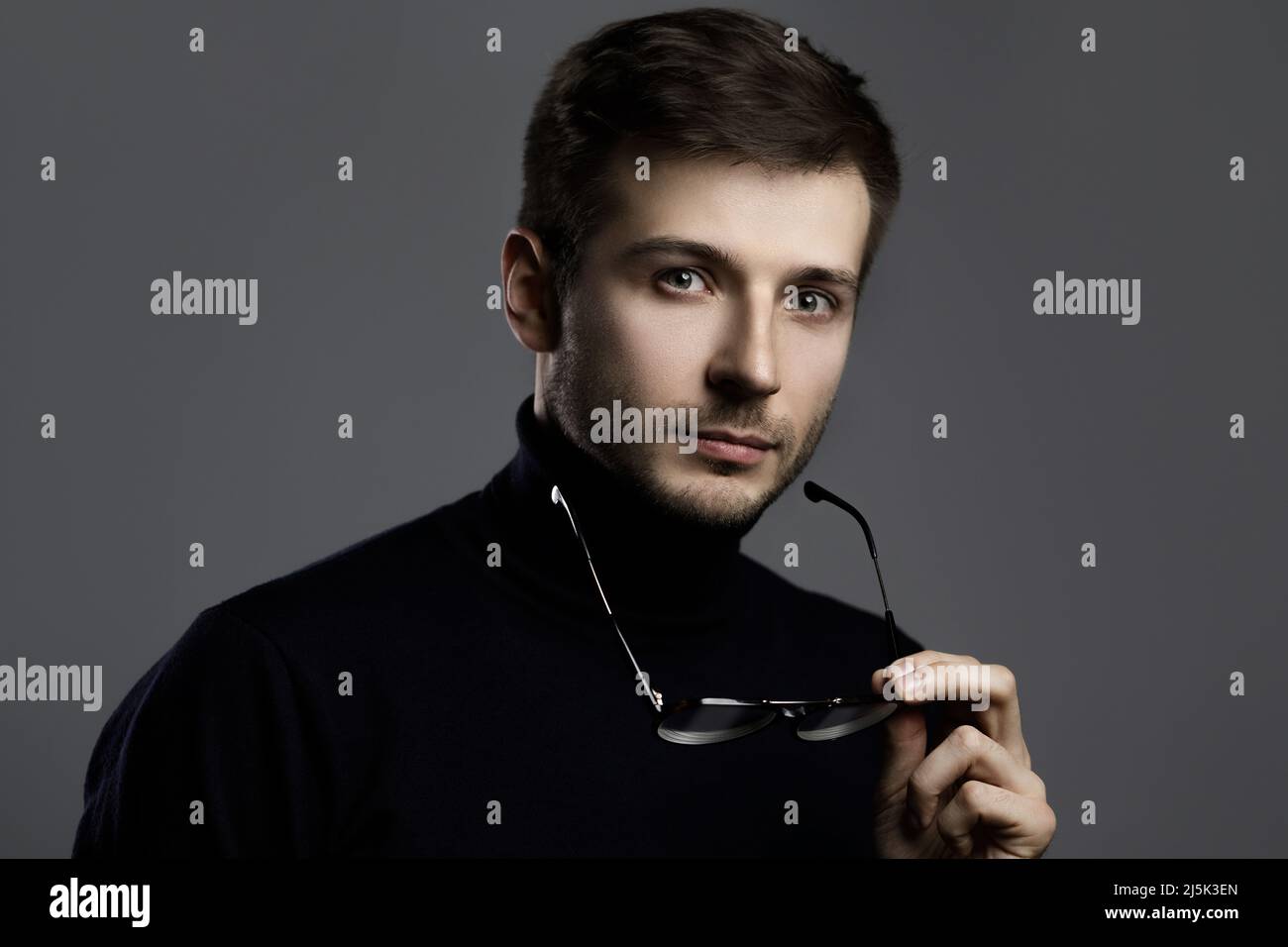 Young intelligent man wearing turtleneck and eyeglasses on gray ...