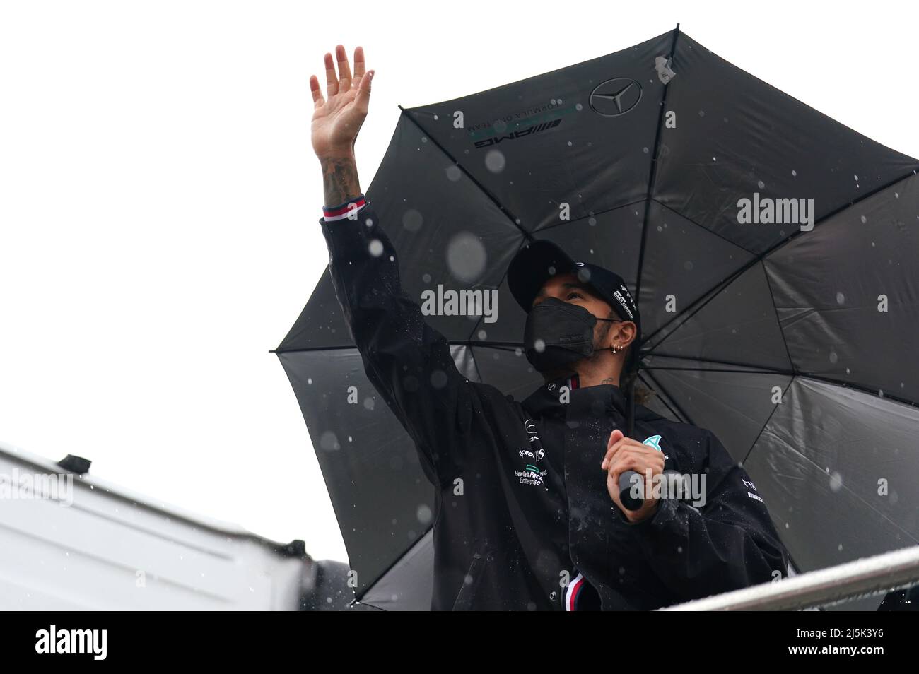 Mercedes' Lewis Hamilton shelters from the rain before the Emilia ...