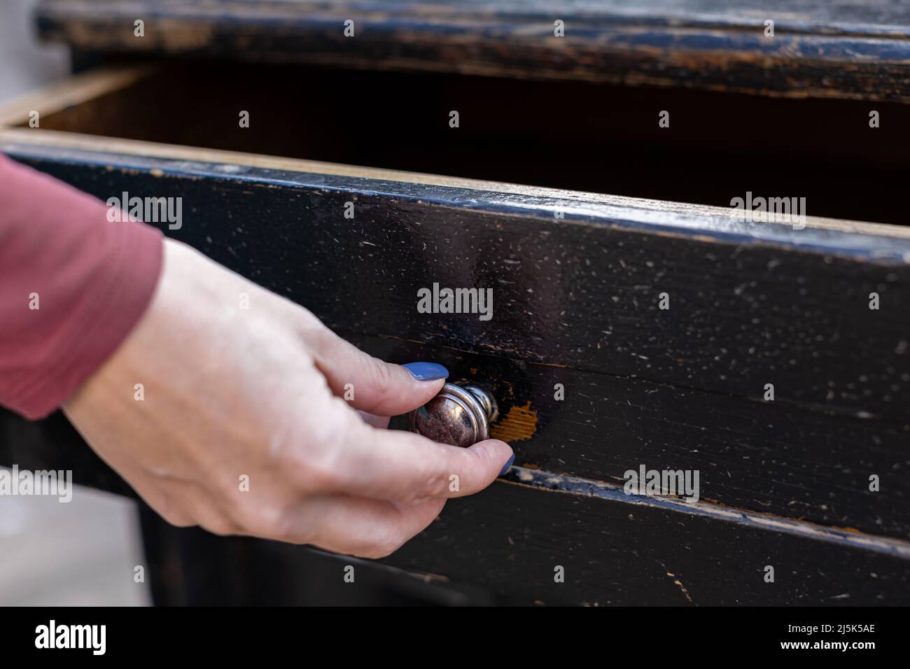 a woman's hand opens a drawer of an old chest of drawers. High quality ...