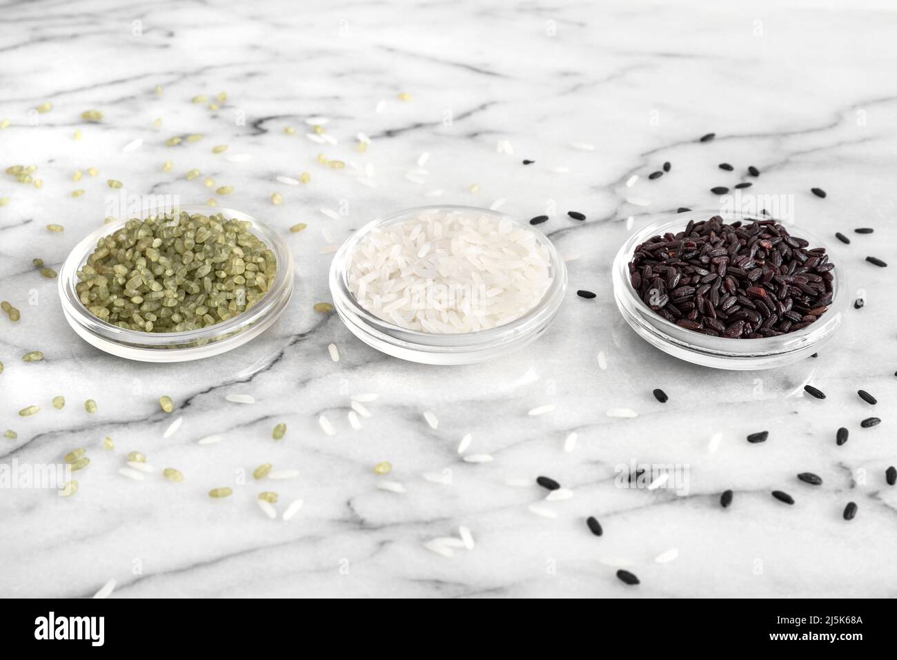 Three varieties of rice, green, white and black, in glass bowls Stock ...