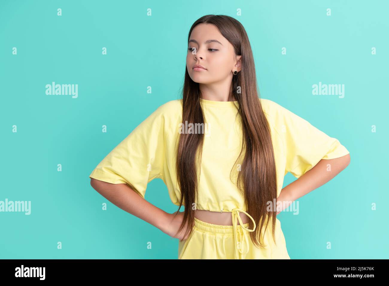 arrogant kid with long hair on blue background with copy space ...