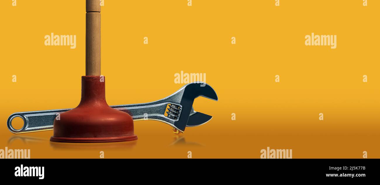 Close-up of a red rubber plunger with wooden handle and a modern ...