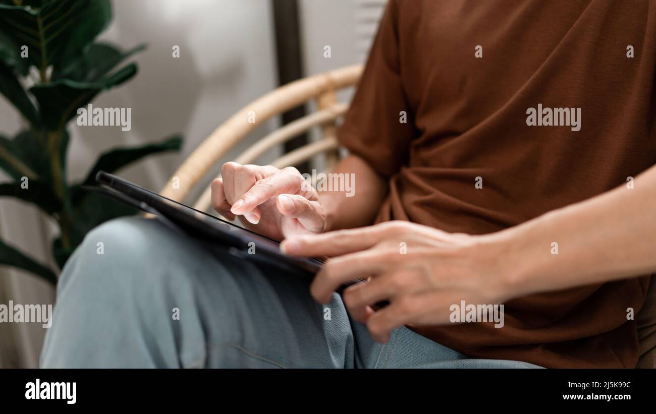 Technology Concept The Male With His Casual T Shirt And Jeans Sitting Comfortably On The Wooden