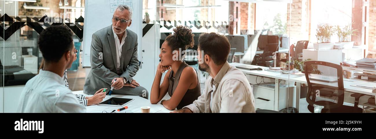 Working process. Mature businessman talking about something with his ...