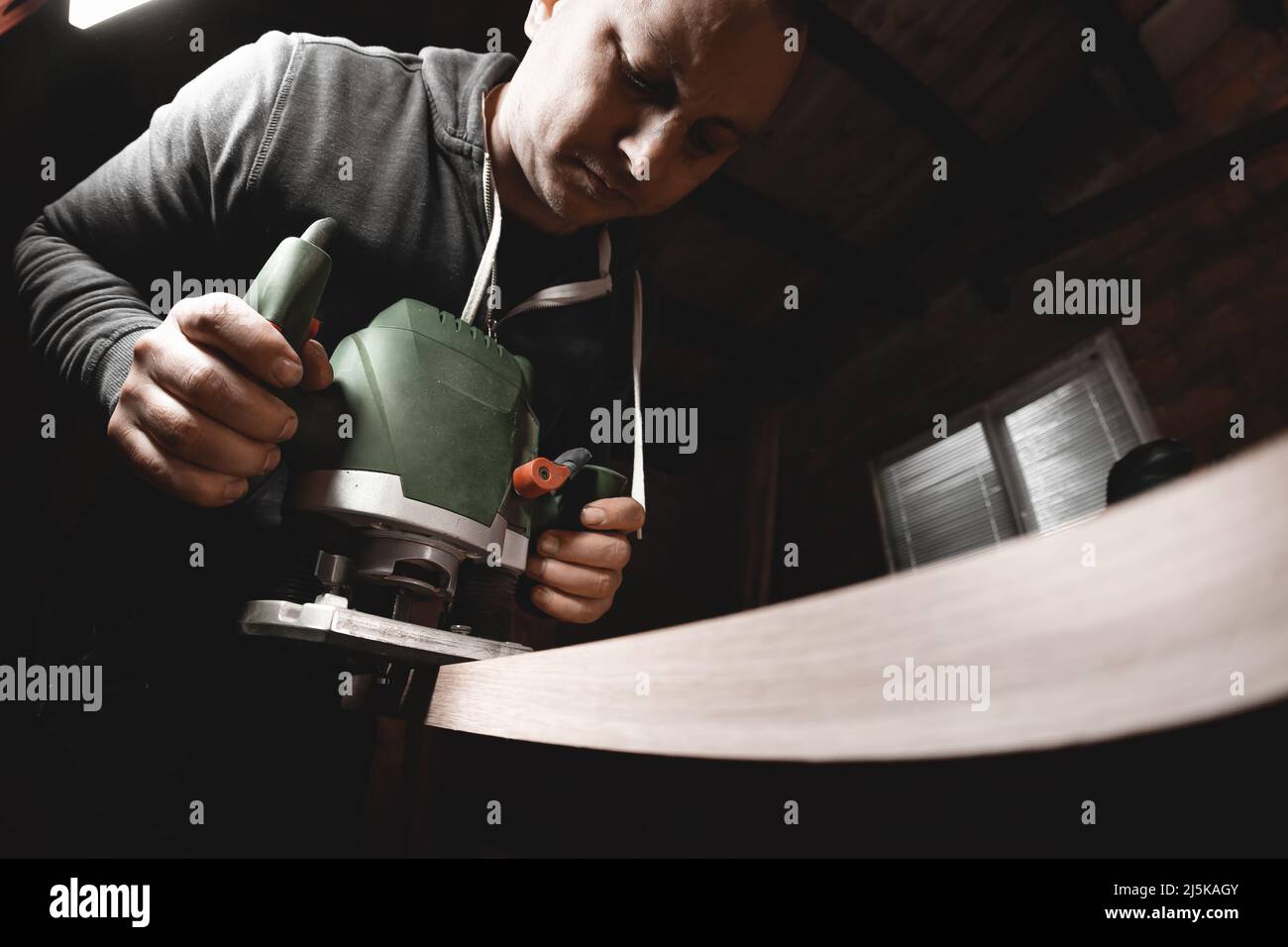 Carpenter with hand electric router machine at work Stock Photo - Alamy