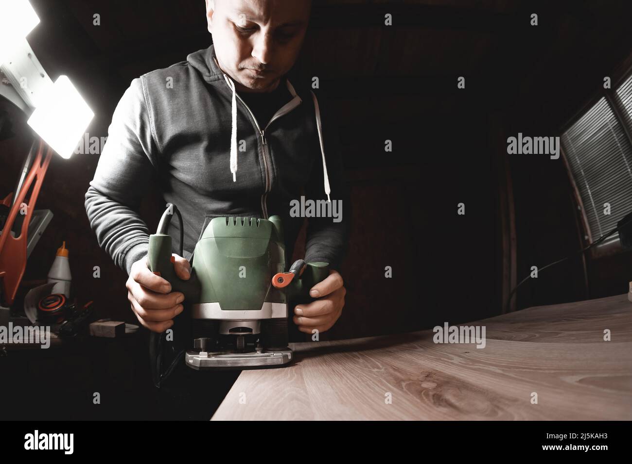 Carpenter with hand electric router machine at work Stock Photo - Alamy