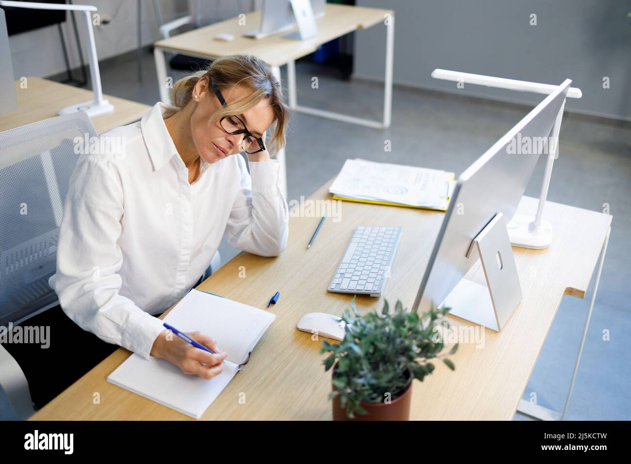 Confident female worker writing hi-res stock photography and images - Alamy