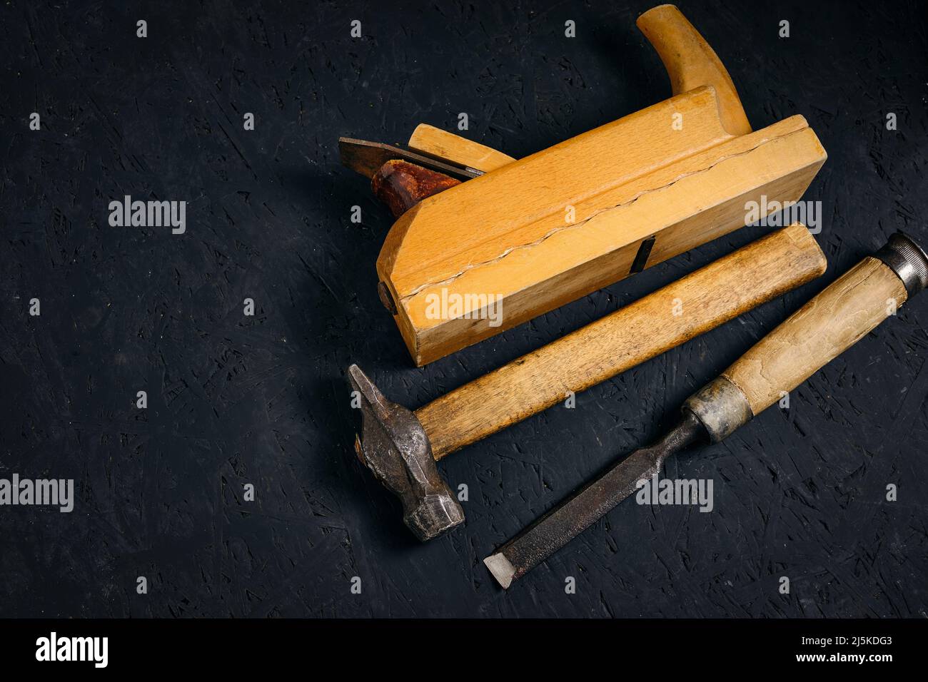 Set of tools for carpenters, hammer, chisel and plane on dark ...