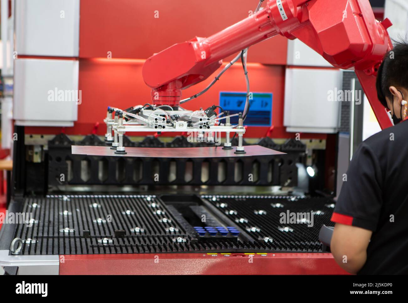 Robot arm loading metal sheet to laser cutting machine in production ...