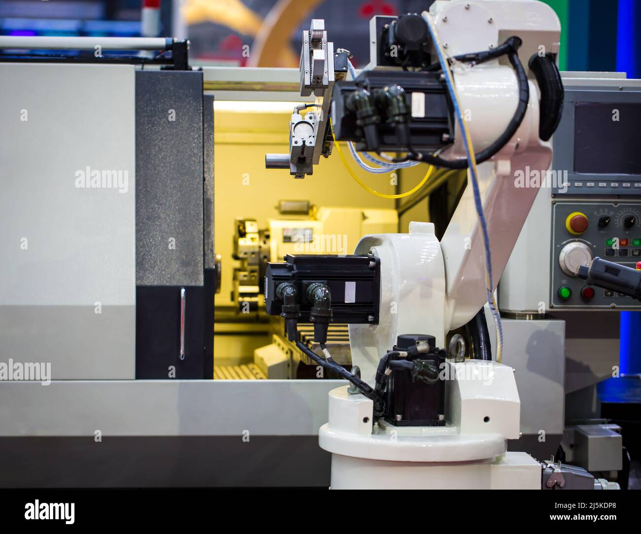 Modern factory. Robot feed workpiece on CNC lathe machine. Industrial ...