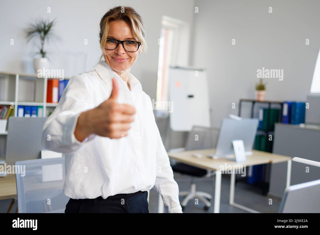 Portrait of mature business woman showing thumbs up. Happy female ...