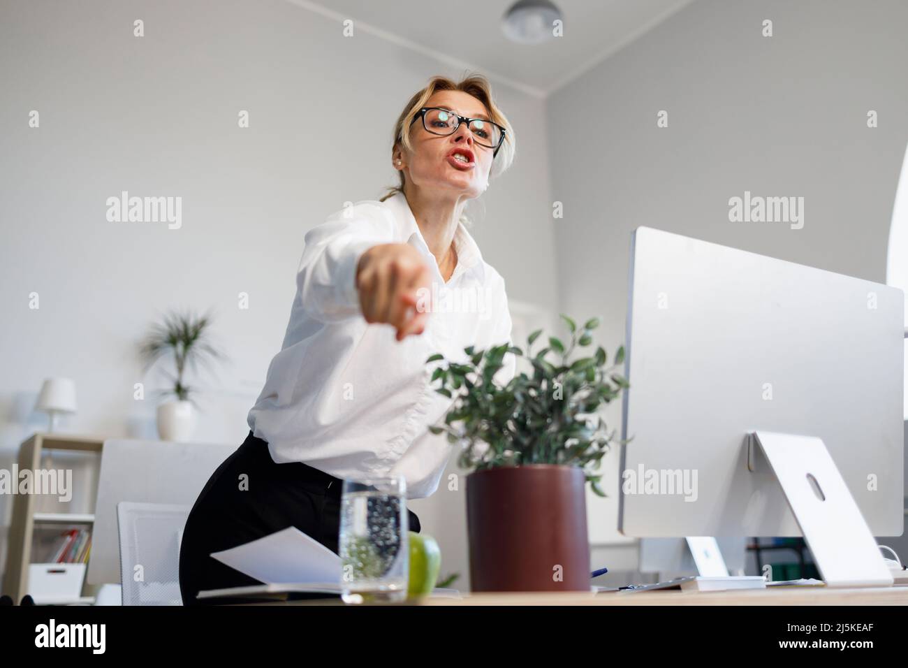 Business woman screaming and pointing finger at subordinate. Angry boss ...
