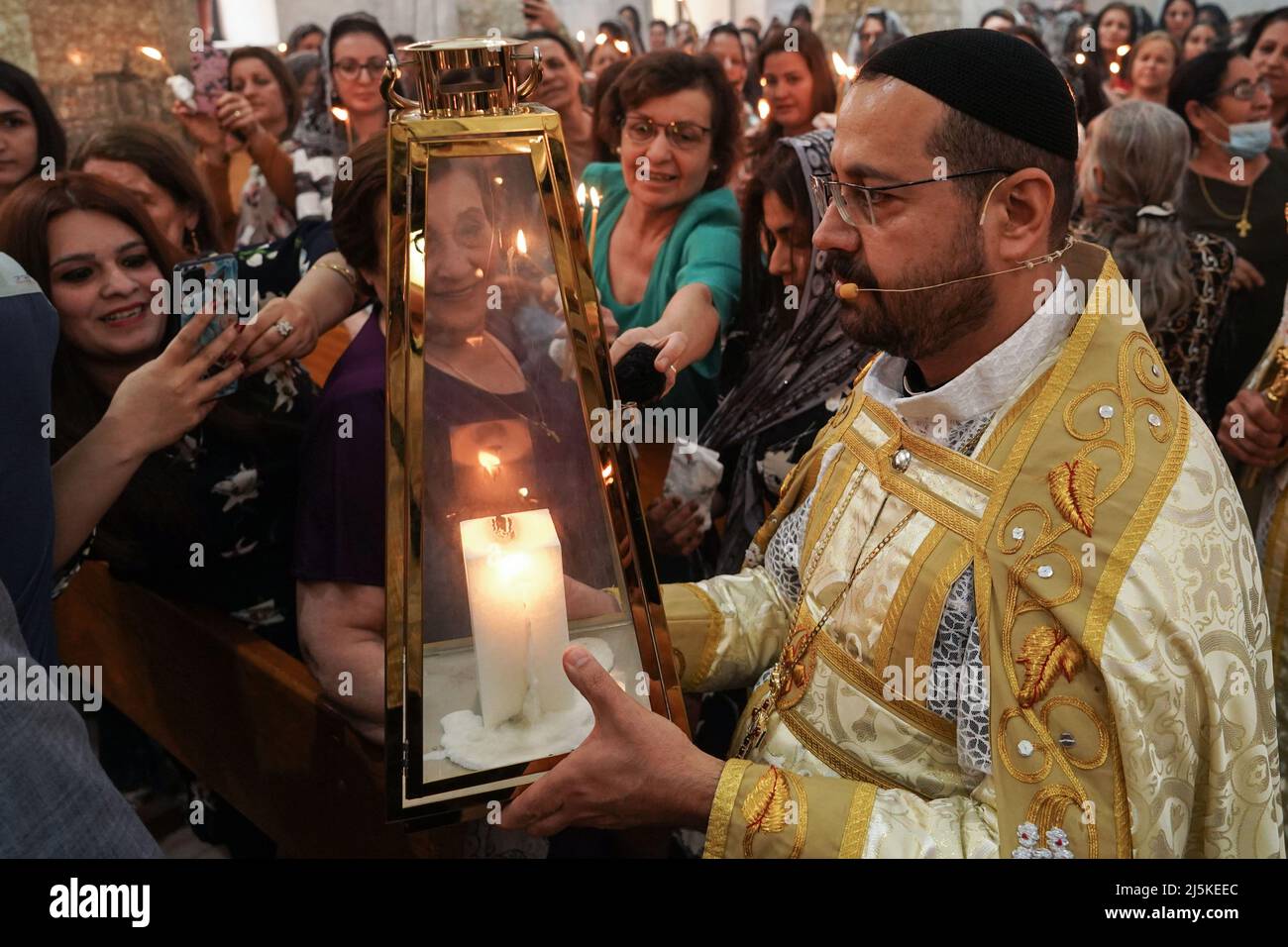 Bartella, Iraq. 24th Apr, 2022. Believers try to reach for the flame of ...