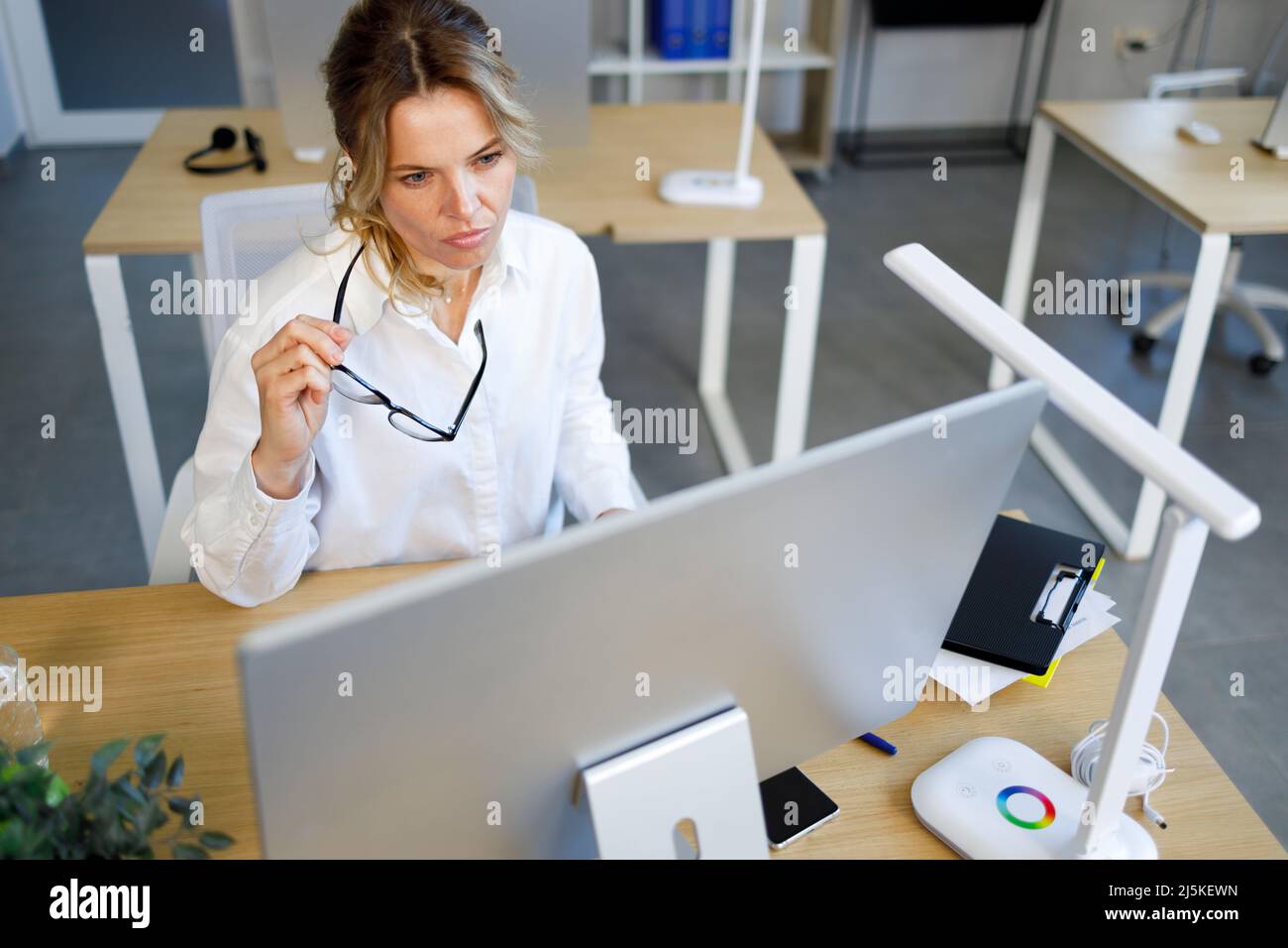 Sad worried female business woman working on laptop in office workplace ...