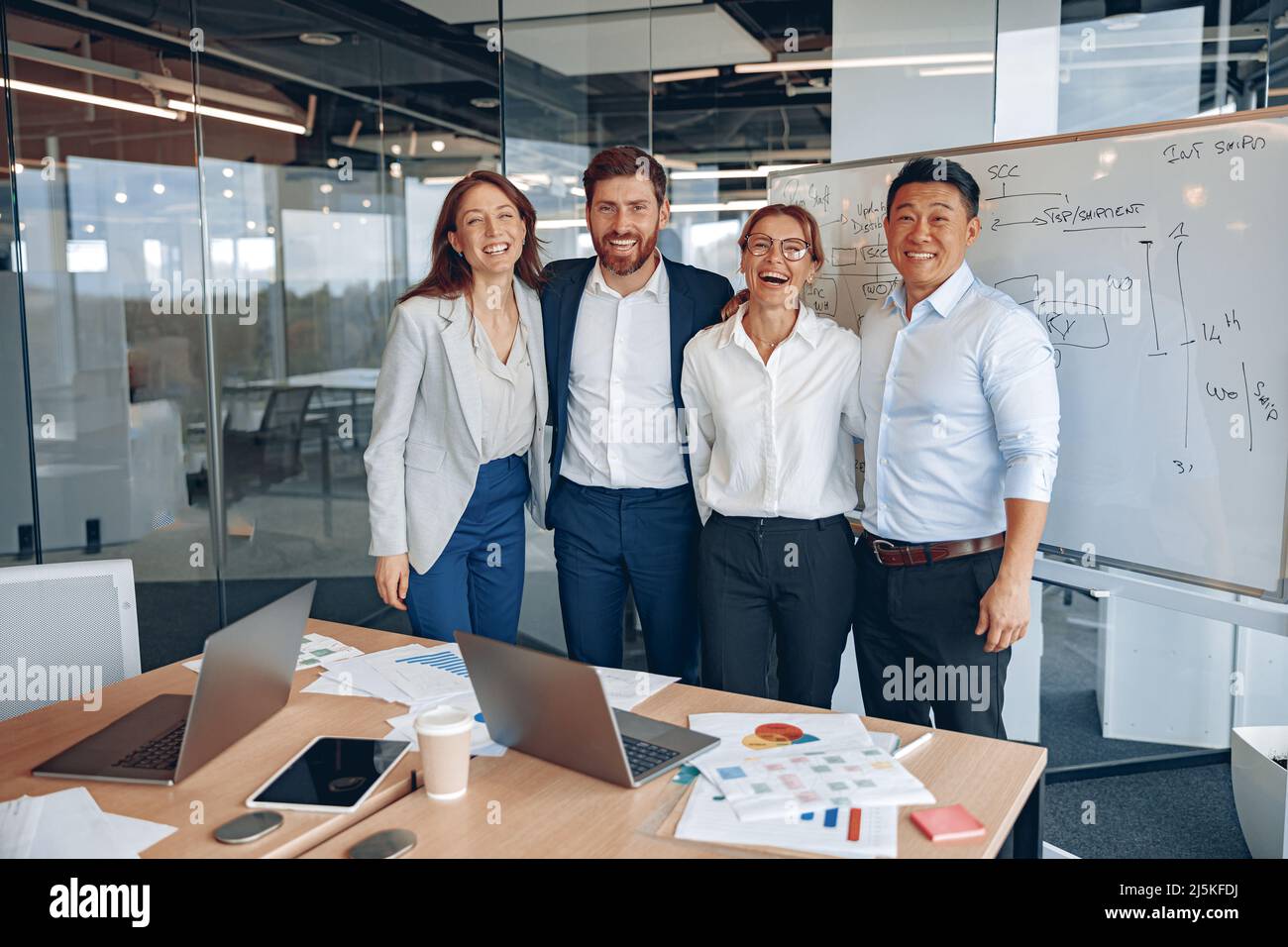 Happy diverse professional business team stand in office near board ...
