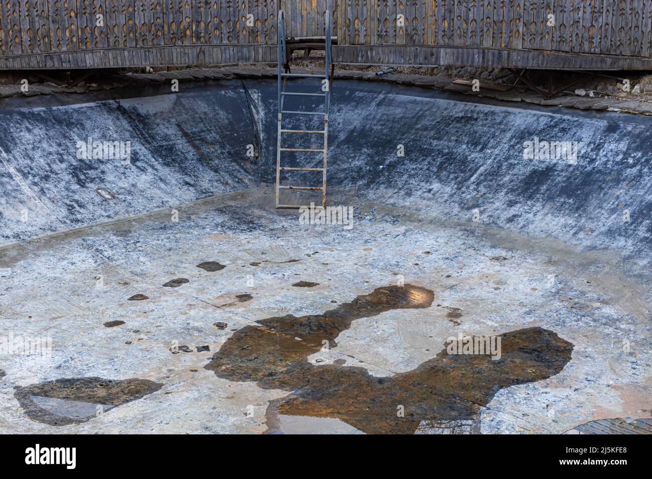 the space of an empty old pool with a staircase descending into it ...