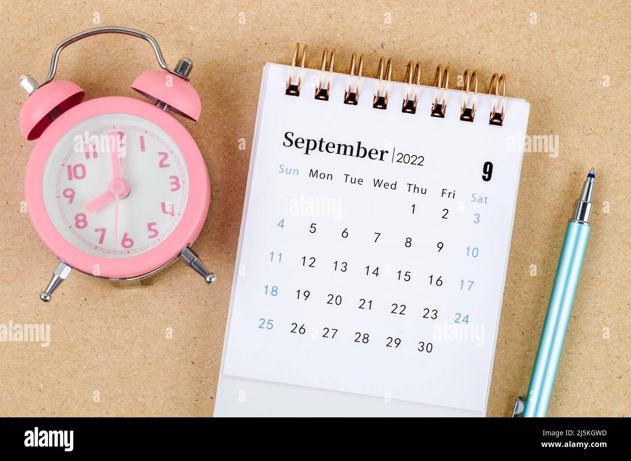The September 2022 Desk calendar with pink alarm clock on brown ...