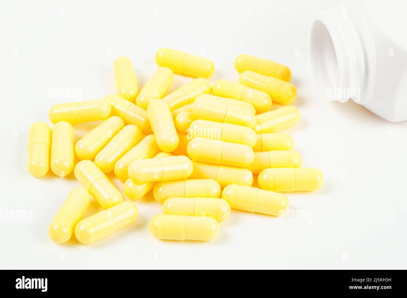 The Yellow pharmaceutical medicine capsules over white background ...