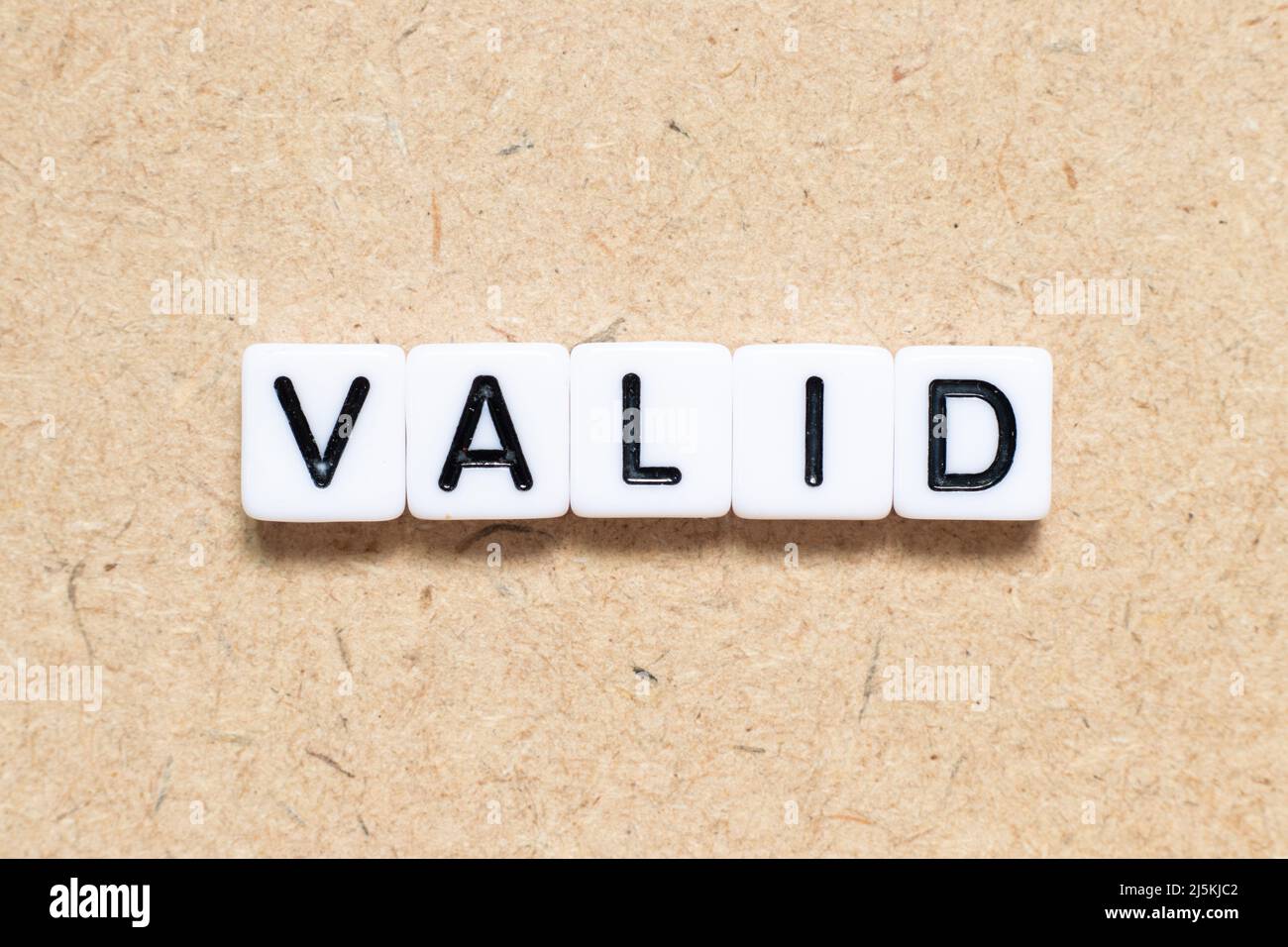 White tile alphabet letter with word valid on wood background Stock ...