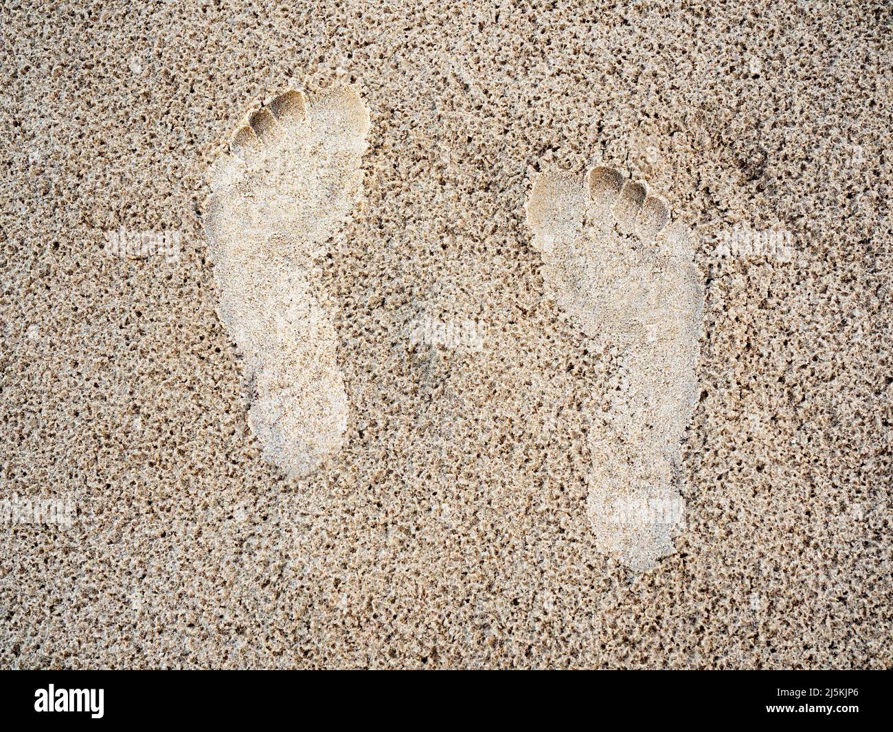 Close-up footprint in the sand beach background. Human foot step track ...