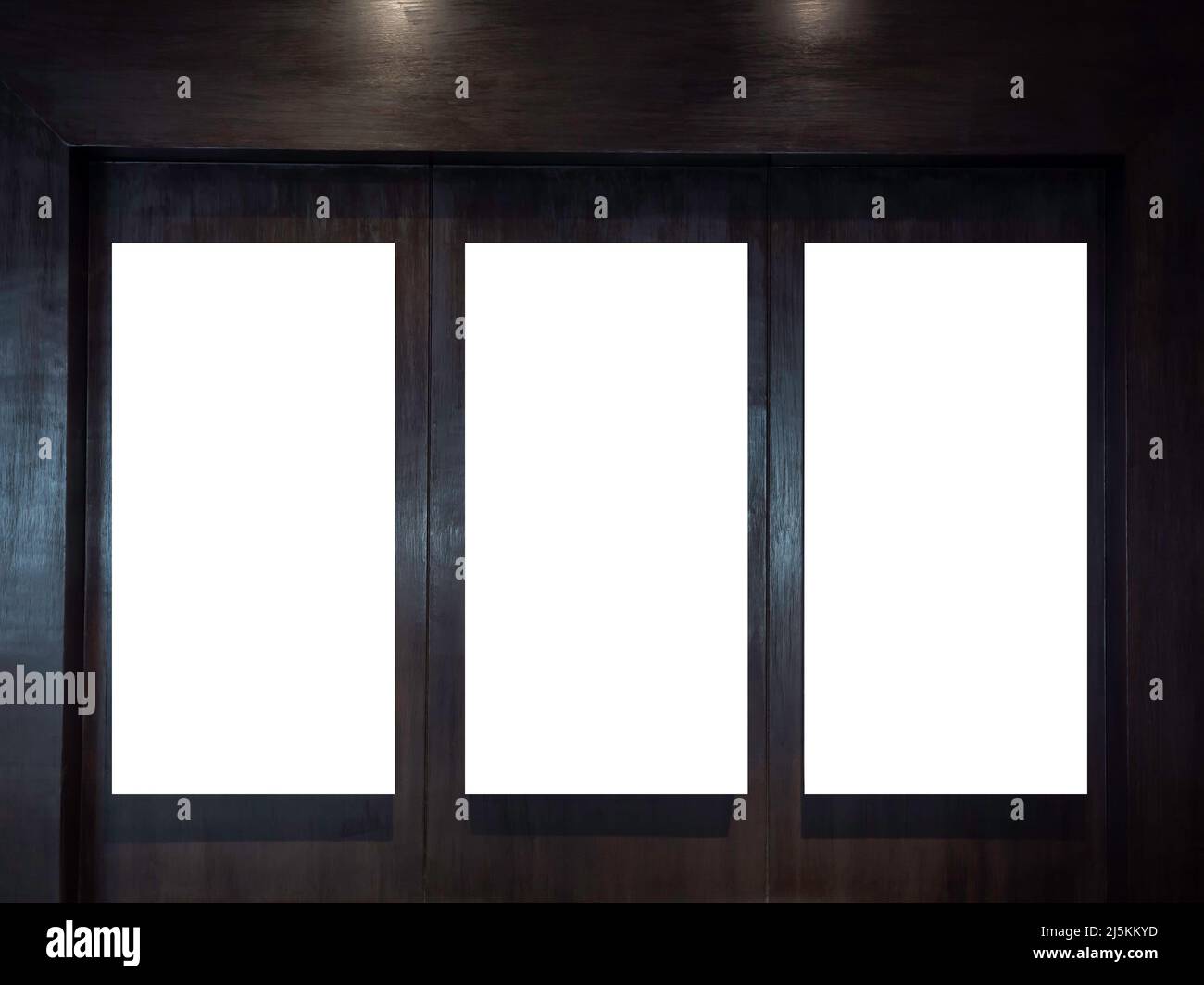 Three mockup vertical rectangle painting frames hanging on dark wood ...