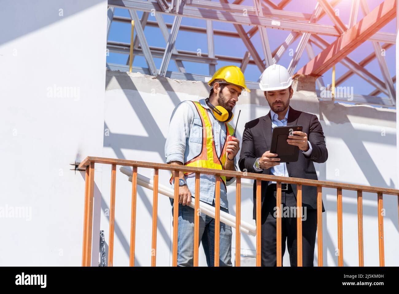 Architect and developer with blueprints discussing architect project at ...