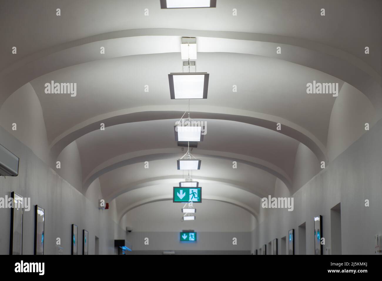 White ceiling in the corridor with glowing exit signs Stock Photo - Alamy