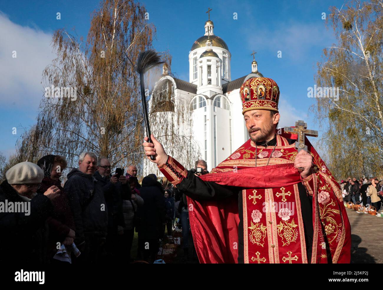BUCHA, UKRAINE - APRIL 24, 2022 - A priest blesses people and their ...