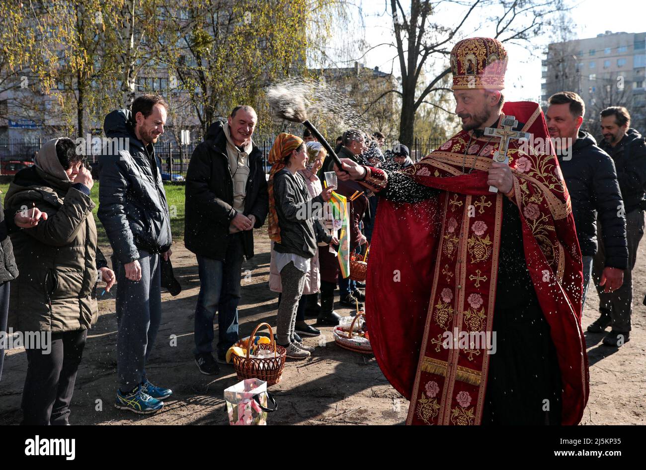 BUCHA, UKRAINE - APRIL 24, 2022 - A priest blesses people and their ...