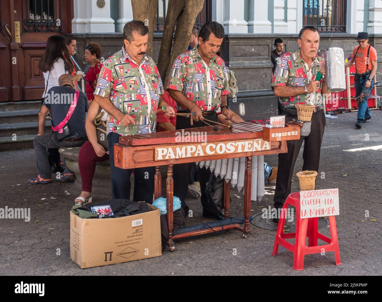 Three street musicians playing a marimba and a guiro in San José, Costa ...