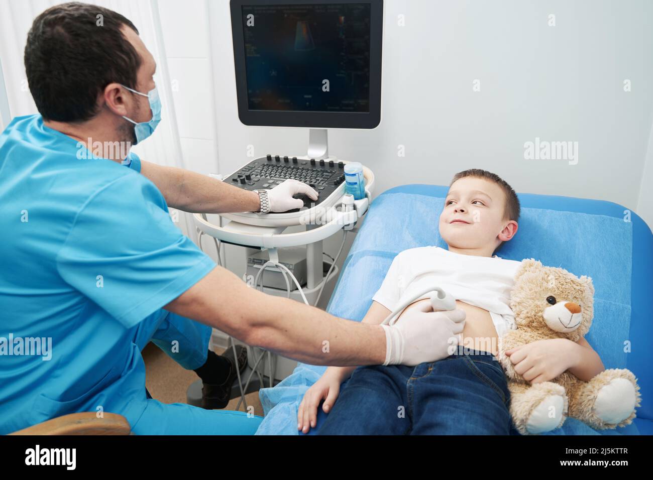 Examining of the child abdomen in the doctor office Stock Photo - Alamy