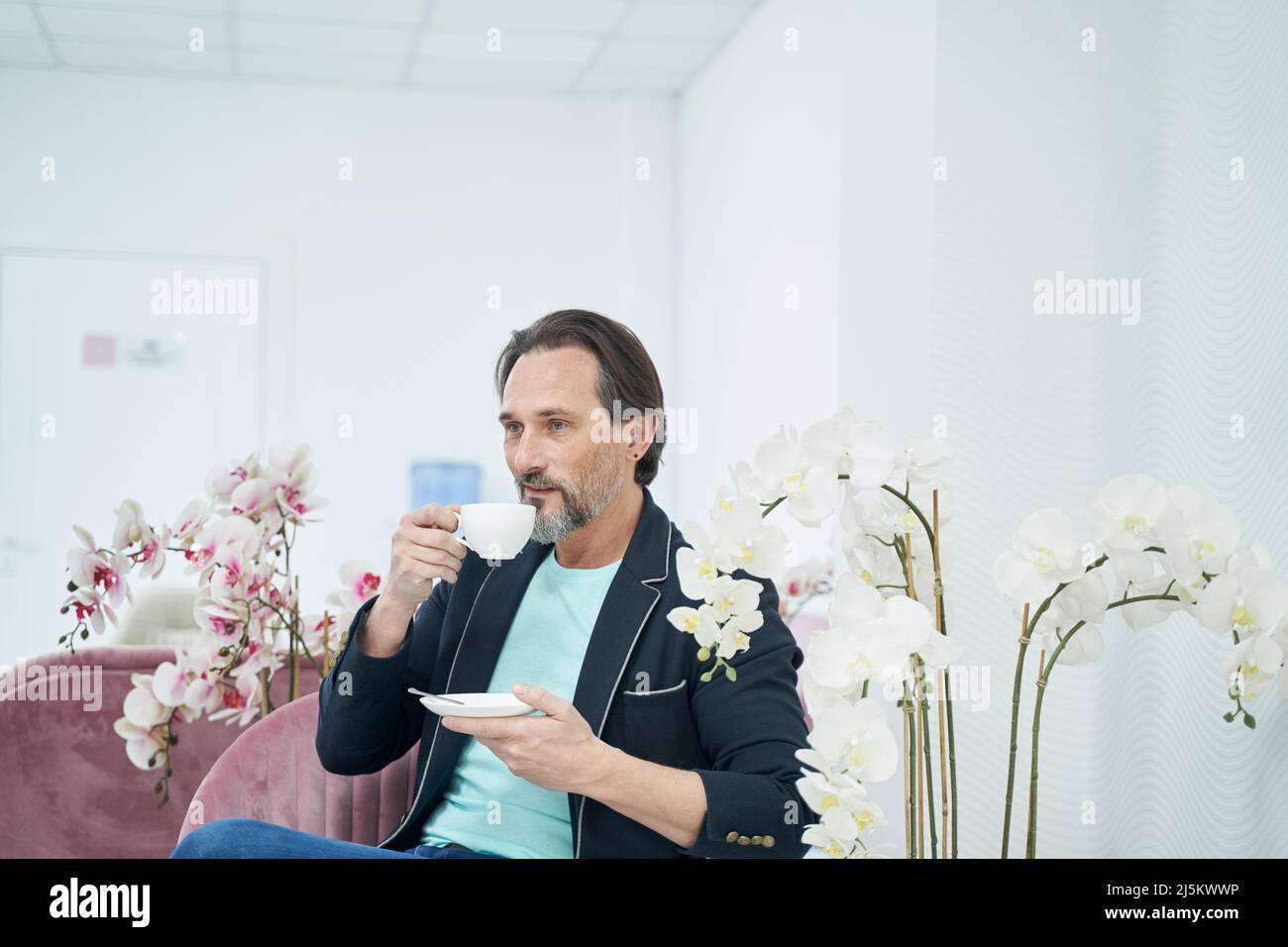 Relaxed male person thinking positive in the lobby Stock Photo - Alamy