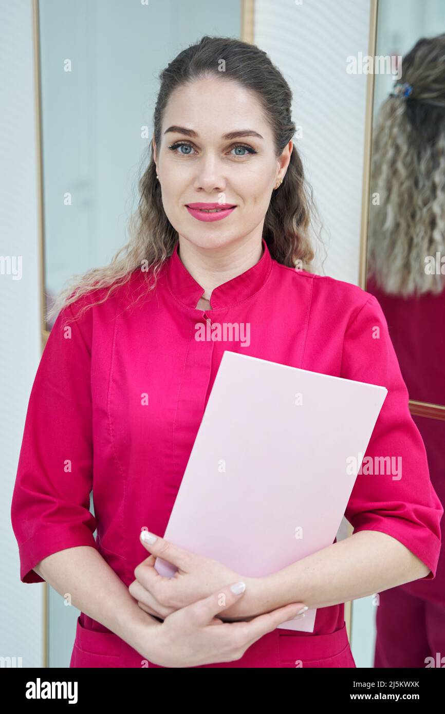 Pretty salon worker looking straight at camera Stock Photo - Alamy