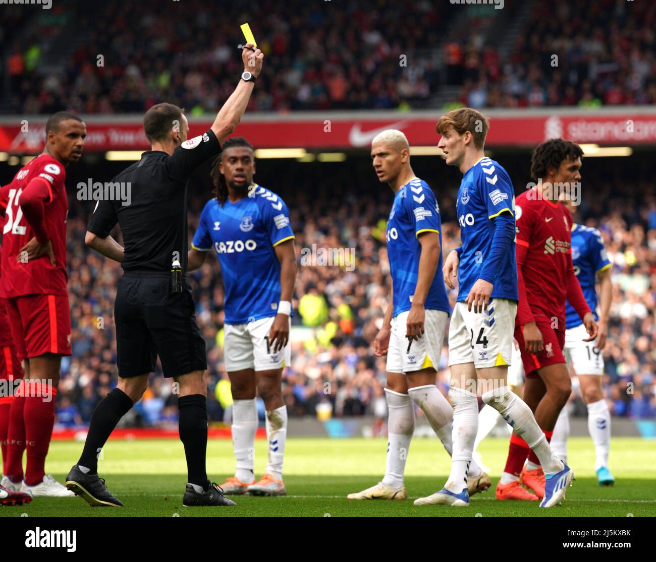 Referee Stuart Attwell shows a yellow card to Everton's Anthony Gordon ...
