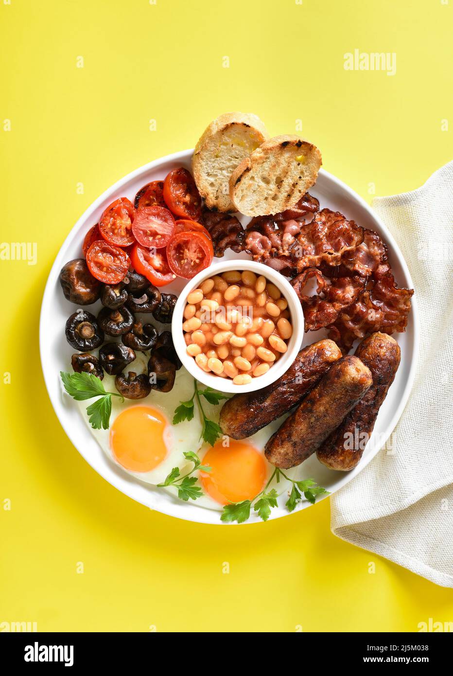 Full english breakfast with fried egg, bacon, sausage, beans and ...