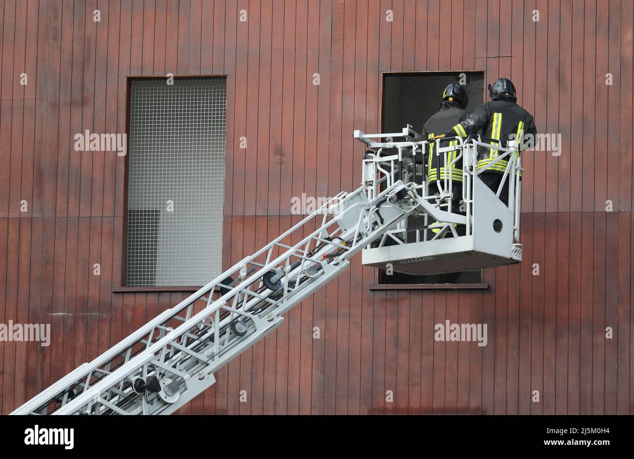 firefighter in action in the fire station with the basket of the ladder ...