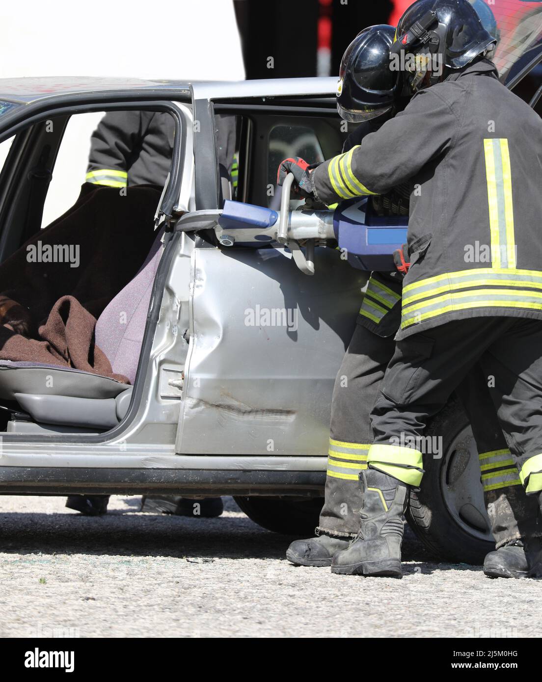 firefighters cutting the sheets of the crashed car with a powerful ...