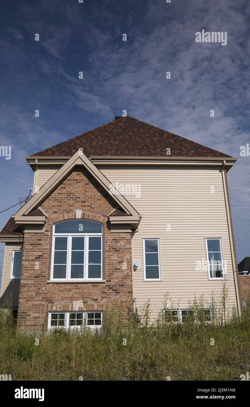 Residential cottage style model home next to vacant lot in a new ...