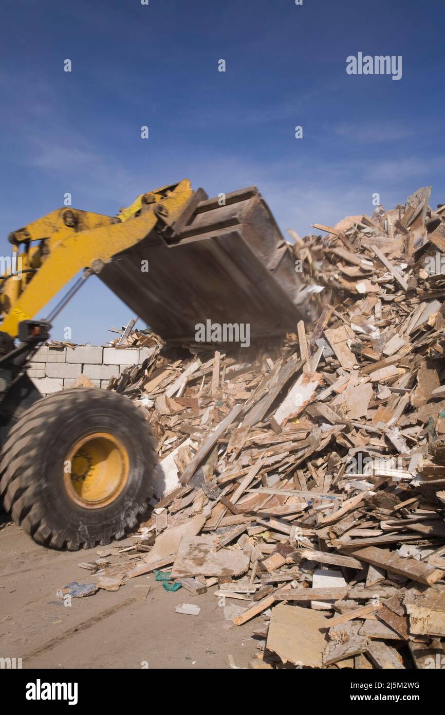Bucket loader dumping debris into a pile at a recycling yard Stock ...