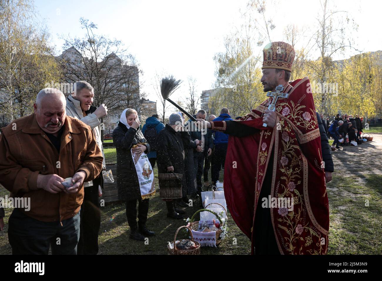 Bucha, Ukraine - April 24, 2022 - A priest blesses people and their ...