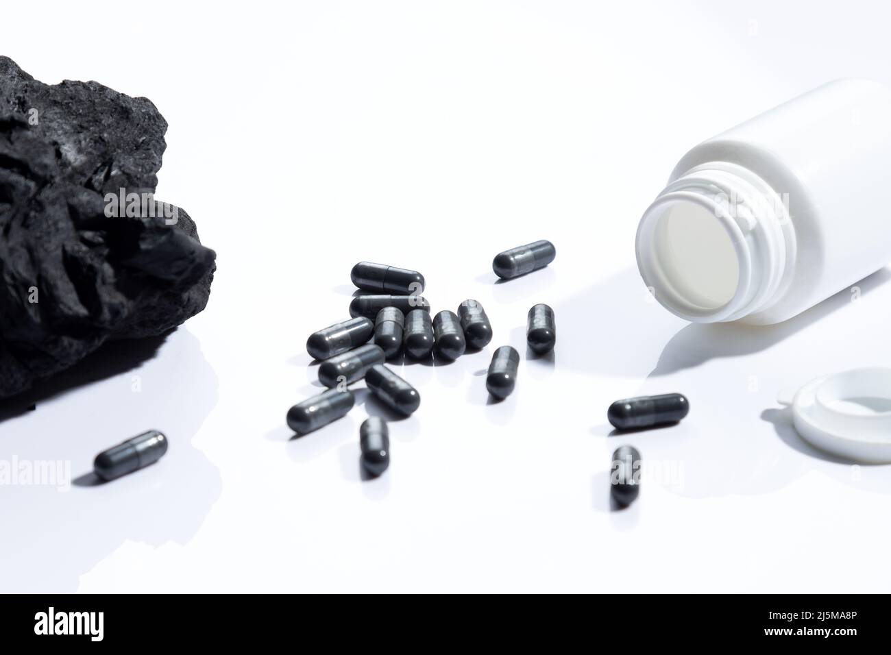 Vegetable carbon capsules on white background. Dietary supplements ...