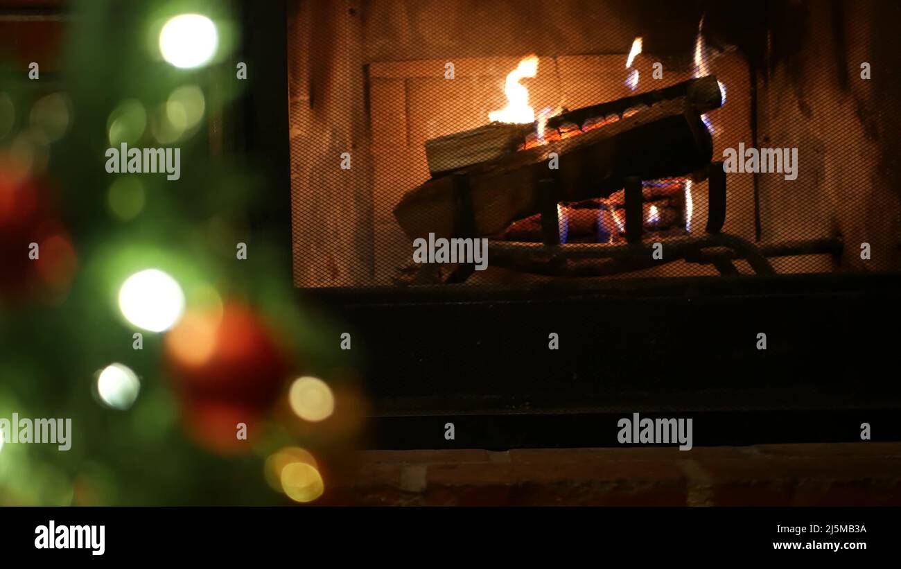 Christmas tree lights by fire in fireplace, New Year or Xmas decoration ...