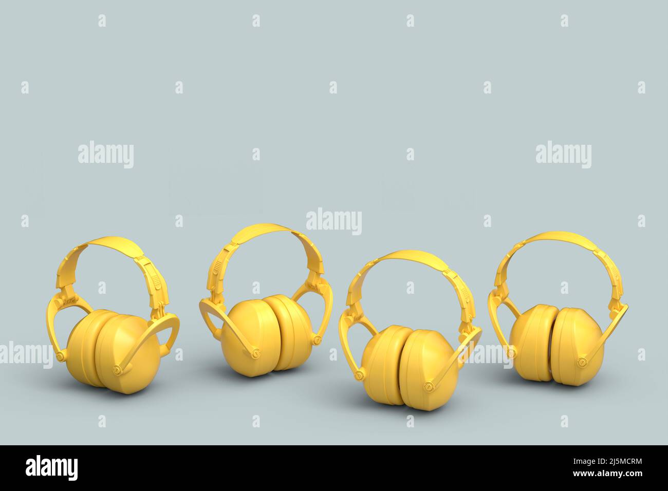 Set of protective yellow earphones muffs isolated on a grey background ...