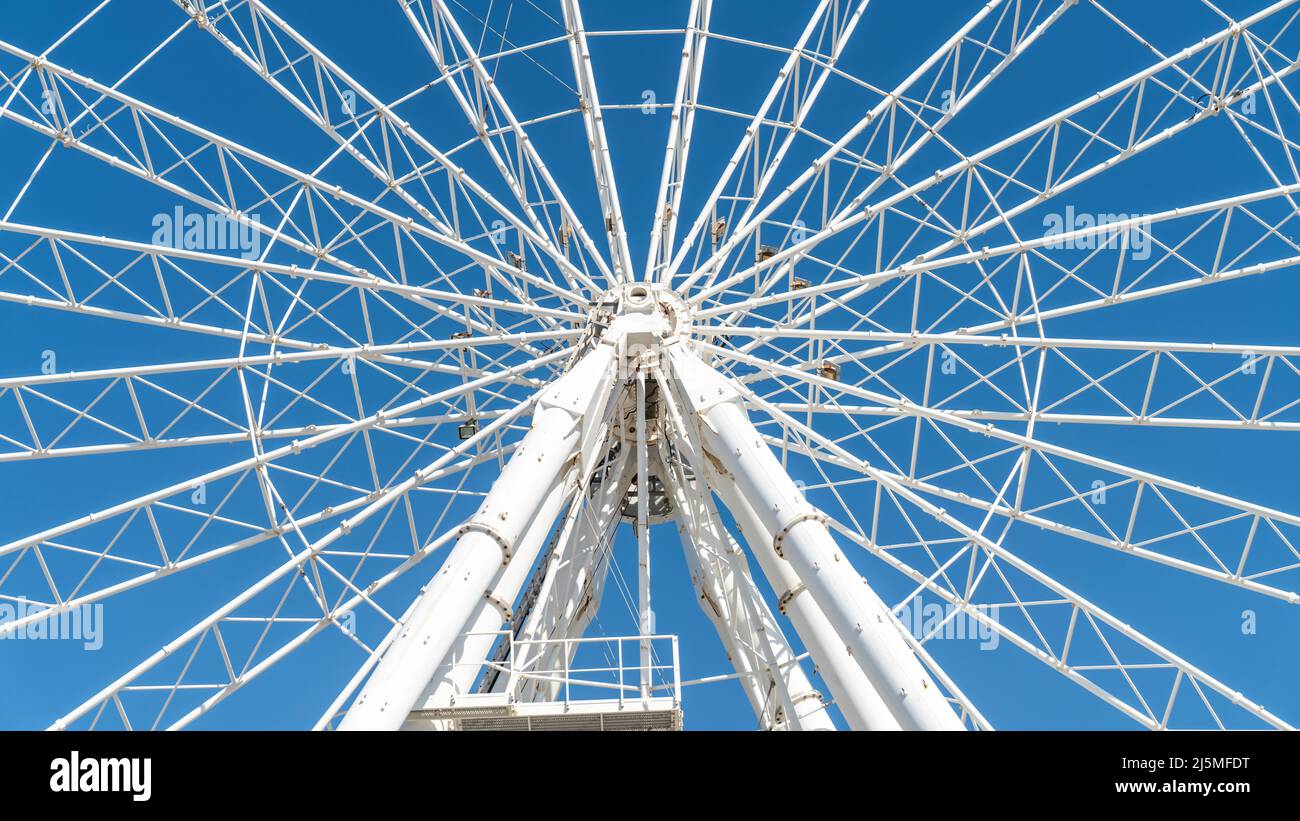 Close-up details of ferris wheel on clear blue sky background, with ...